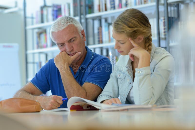 Two People in Library Looking through Book Stock Image - Image of ...
