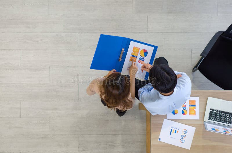 Two People are Looking at Chart and Graph during a Meeting from a Top ...