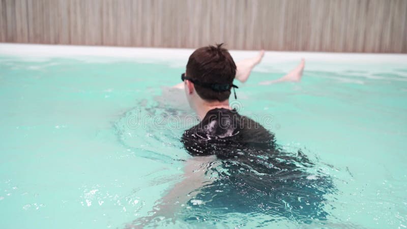 Two People Practicing Swimming Techniques in a Pool, Focusing on ...