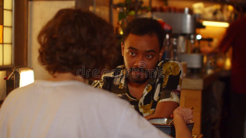 Two Young People Sit at a Table in a Cafe, they Eat Food and Talk ...