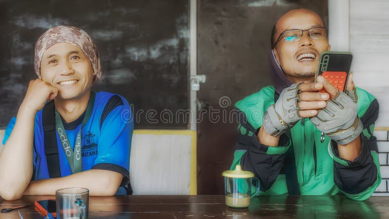 Two People Sitting at a Table with Mobile Phones Editorial Photography ...