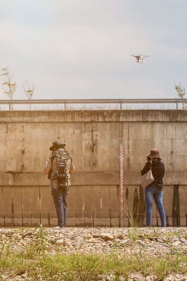 Two People Standing and Control Drone Fly in the Air. Editorial Stock ...