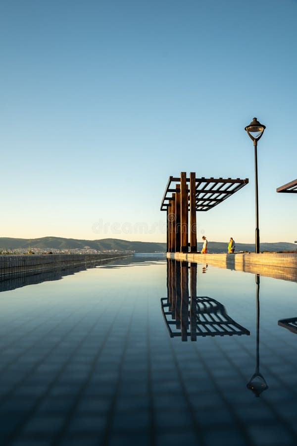 Two People Standing by Infinity Pool Enjoying Sunrise Over Mountain ...