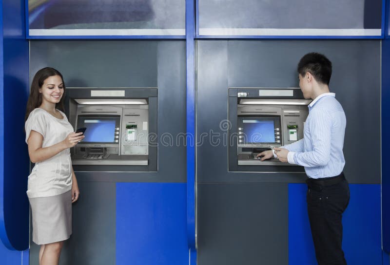 Two People Standing and Withdrawing Money from an ATM Stock Photo ...