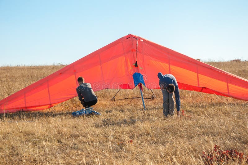Two People Glide with a Parachute Against the Blue Sky. Selective Focus ...