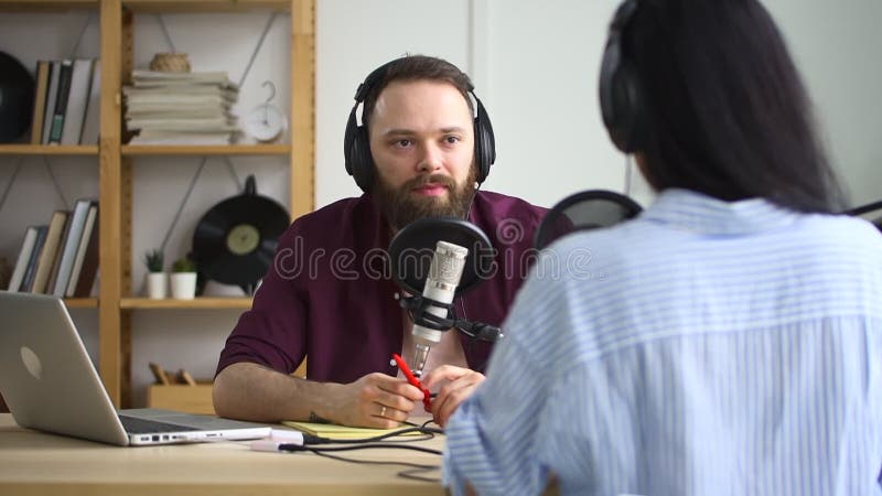 Two People Talking and Sitting at Table in Studio during Radio ...