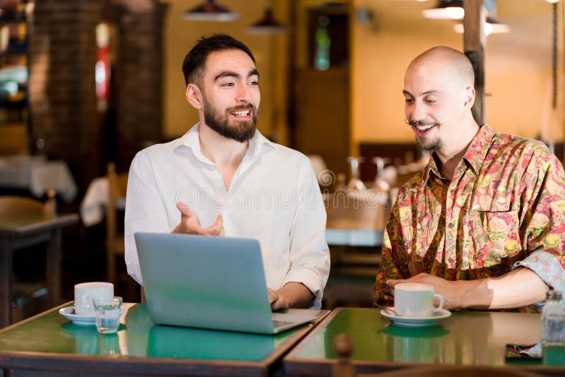 Two People Using a Laptop on a Meeting at a Coffee Shop. Stock Image ...