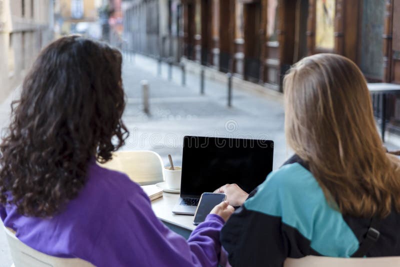 Two People Using Laptop and Mobile Phone while Sitting Outdoors at a ...