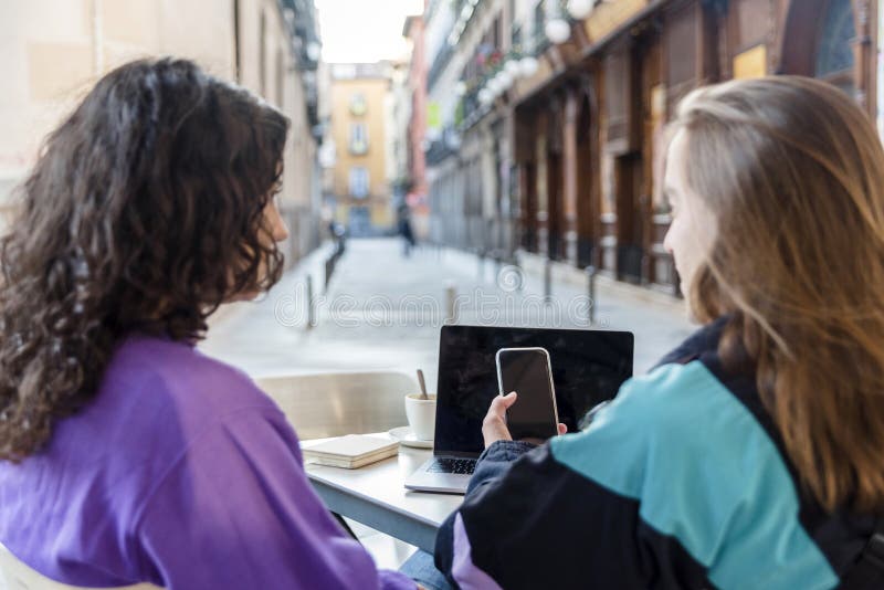 Two People Using Laptop and Mobile Phone while Sitting Outdoors at a ...