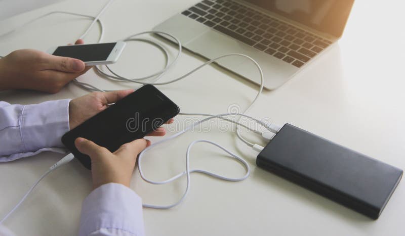 Two People Using Two Mobile Phone Sharing USB Power Bank on a Table To ...