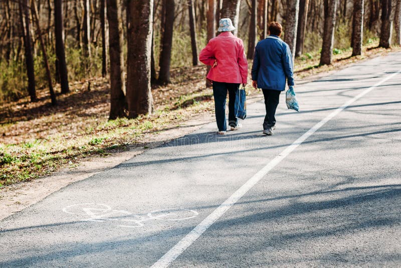 Two People Walk in Park on an Asphalt Road Stock Photo - Image of ...