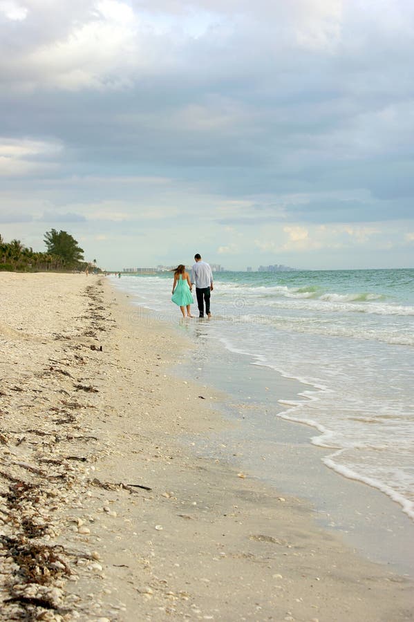 Two People Walking Away from Viewer Along Beach Stock Image - Image of ...