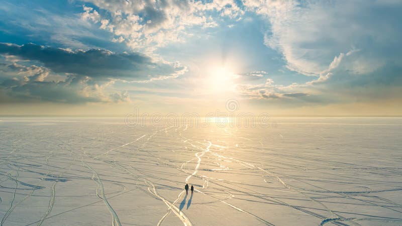 The Two People Walking through the Endless Snow Field. Stock Photo ...