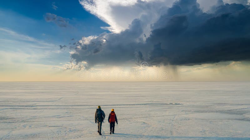 The Two People Walking through the Endless Snow Field. Stock Image ...