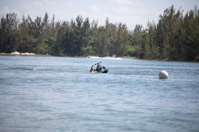 Two People Who Have Fallen Off a Jetski Holding a Jetski on the Water ...