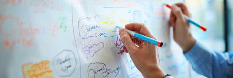 Two People Writing on a Whiteboard with Colorful Notes during a ...