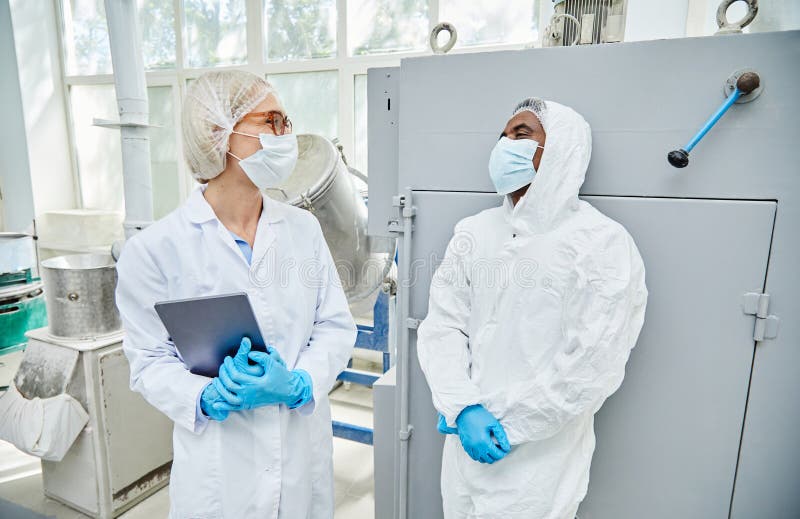 Two Pharmaceutical Industry Workers Smiling while Communicating in ...