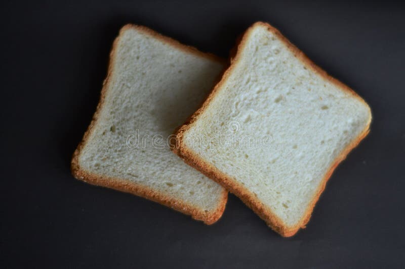 Two Pieces of Bread on a Black Background Stock Photo - Image of icing ...