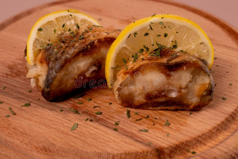 Two Pieces of Fish Baked and Garnished with Lemon Stock Image - Image ...