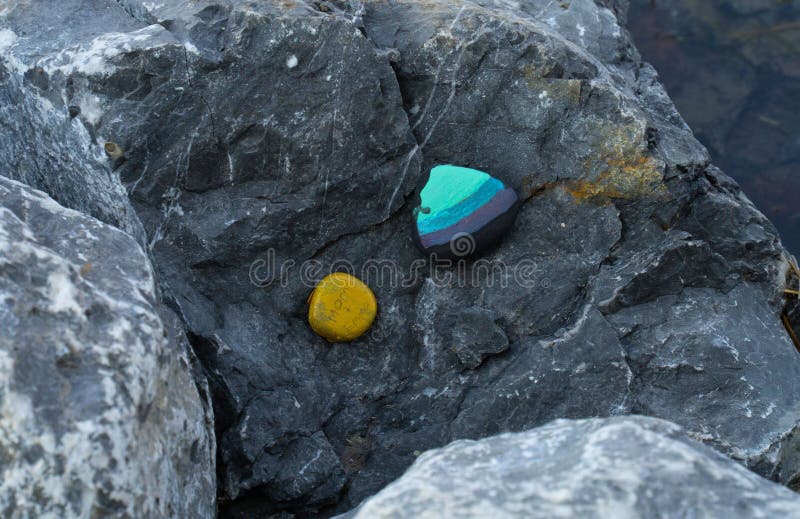 Two Pieces of Yellow and Blue Rock Sit among the Rocks Stock Image ...