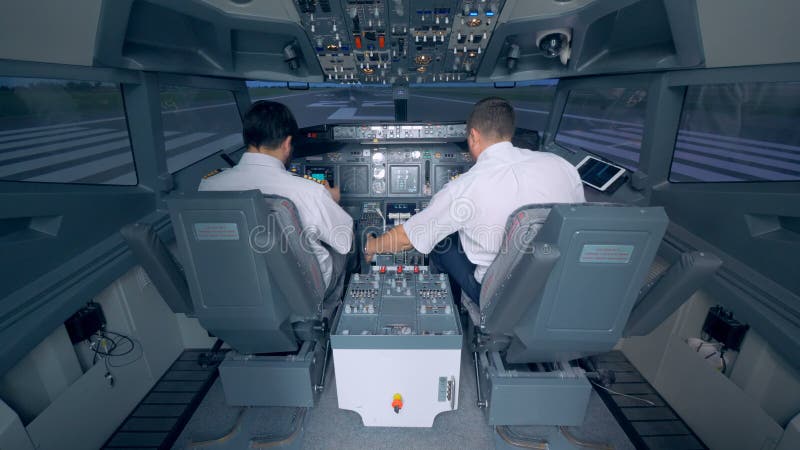 Two Pilots Check Equipment in a Cockpit, Back View. Stock Footage ...