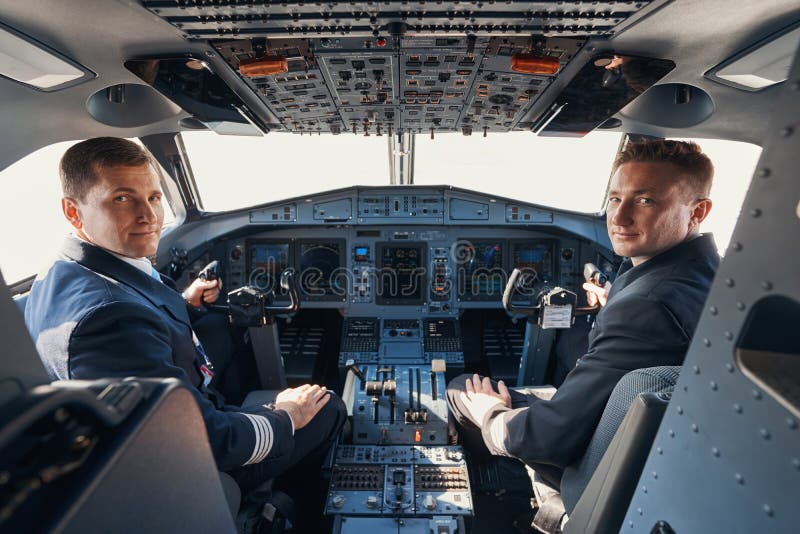 Two Pilots Sitting in Cockpit and Looking at Camera Stock Image - Image ...