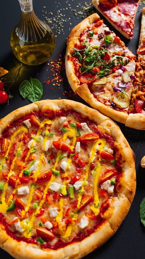 A Couple of Pizzas on Top of a Table Covered in Toppings Stock Photo ...