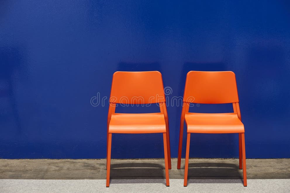 Two Plastic Chairs in Front of a Blue Wall. Solitude Stock Photo ...