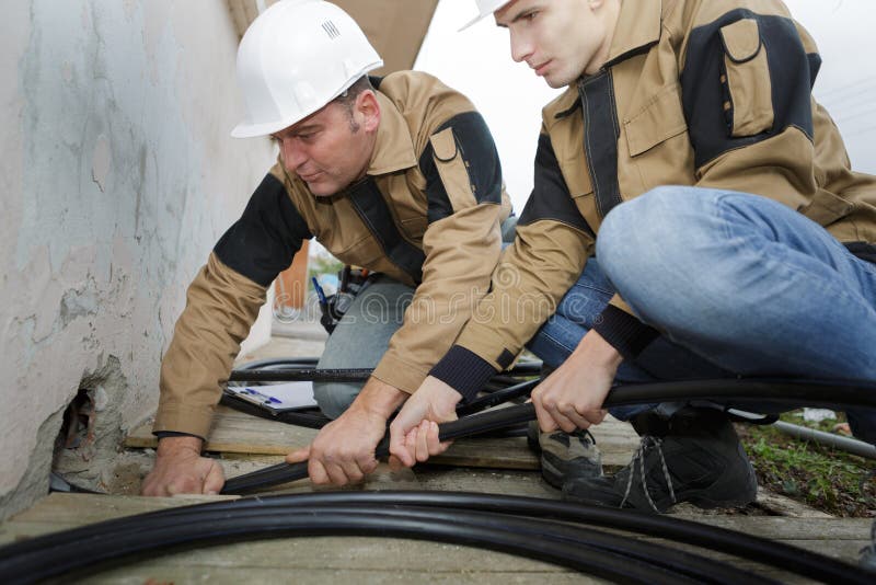 Two Plumbers Fixing Sewerage Pipe at Construction Site Stock Image ...