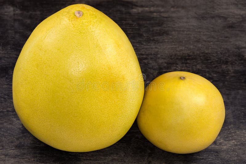 Two Pomelo Fruits Different Sizes on a Black Surface Stock Photo ...