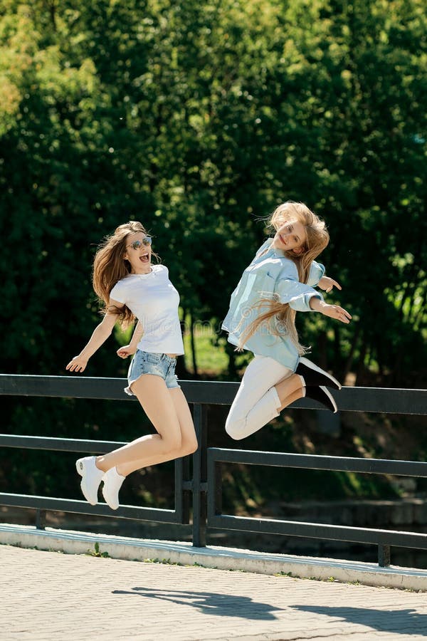 Two Positife Girls Jumping Together Stock Image - Image of jump, bridge ...