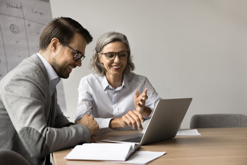 Two Positive Different Aged Colleagues Working at Laptop Computer Stock ...