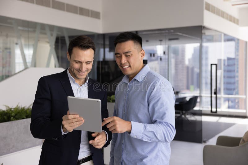 Two Positive Multiethnic Businessmen Standing with Digital Gadget in ...
