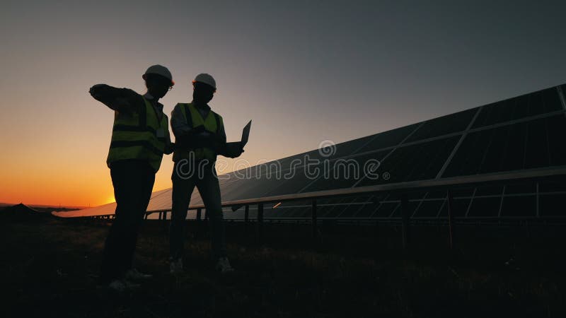 Power Engineers are Talking Near Electrical Transmission Towers Stock ...