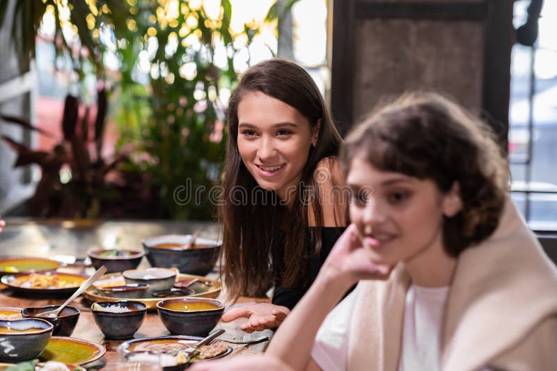 Two Pretty Young Girls Sitting at the Dinner Table and Talking To ...