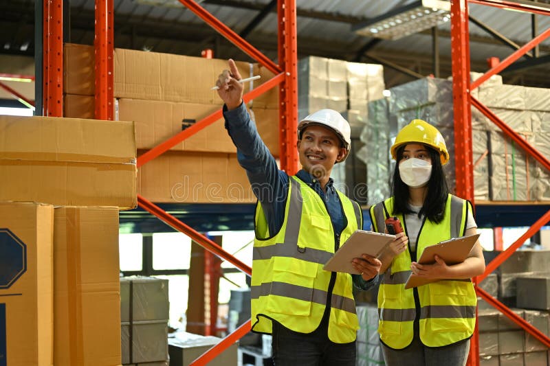 Two Professional Asian Warehouse Workers are Talking and Discussing ... Two Professional Asian Warehouse Workers are Talking and Discussing ...