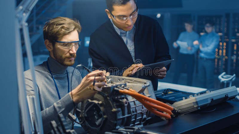 Two Professional Automotive Engineers with a Tablet Computer and ...