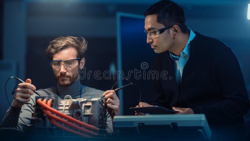 Two Professional Automotive Engineers with a Tablet Computer and ...