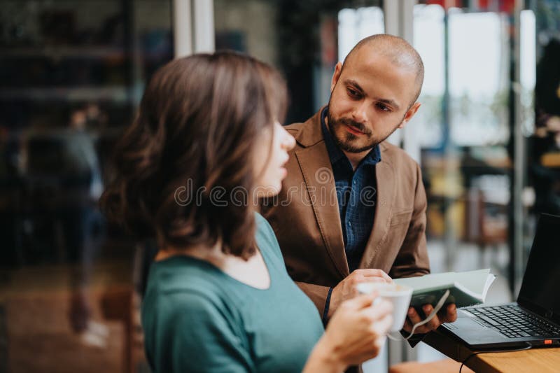 Business Partners Discussing Work with Laptop and Coffee at a Cafe ...