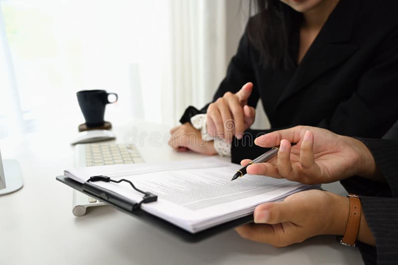 Two Professional Businesswomen Reviewing a Document in a Modern Office ...