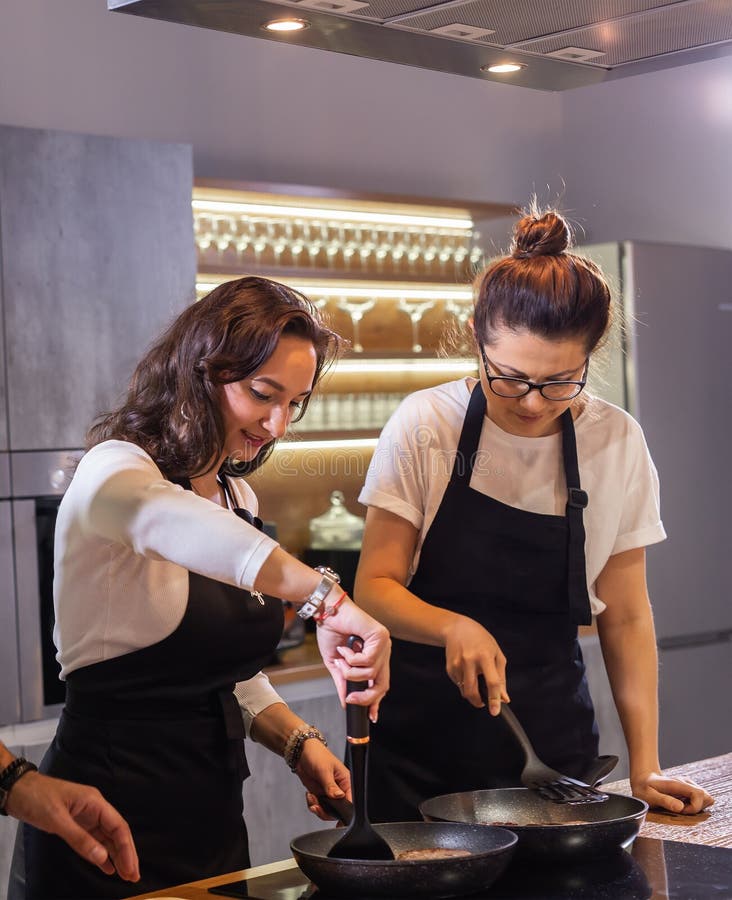 Two Professional Female Chefs Cooking Dishes in Large Kitchen Stock ...