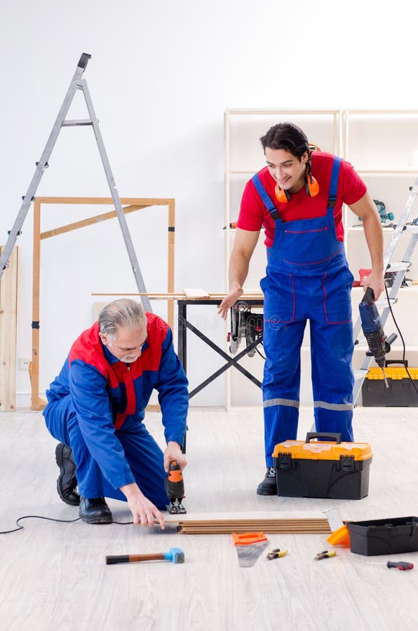 The Two Professional Contractors Laying Flooring at Home Stock Photo ...