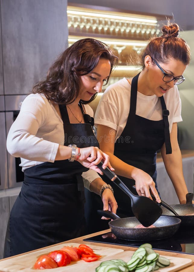 Two Professional Female Chefs Cooking Dishes in Large Kitchen Stock ...