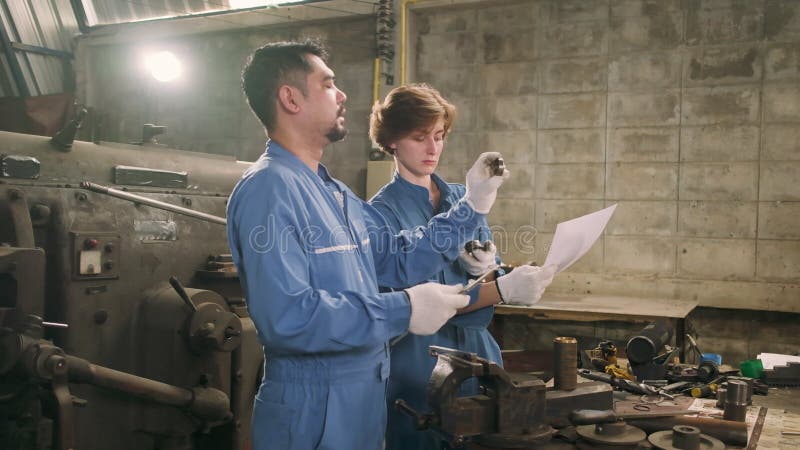 Two Professional Workers Team Working in the Metalwork Manufacturing ...