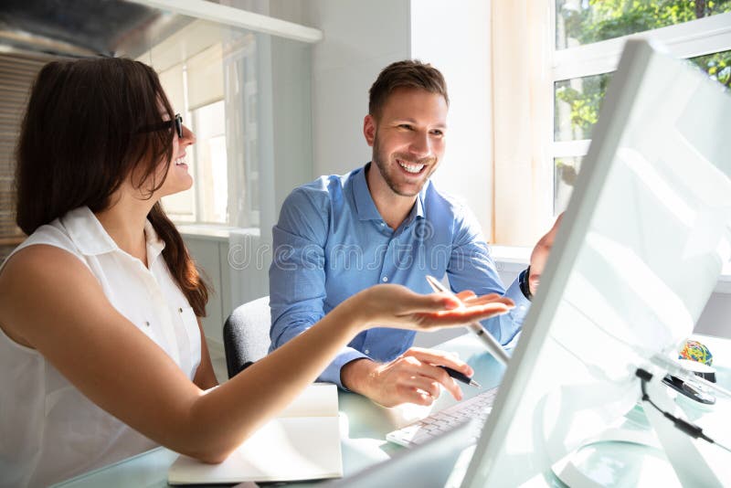 Two Businesspeople Looking at Computer Having Conversation Stock Photo ...