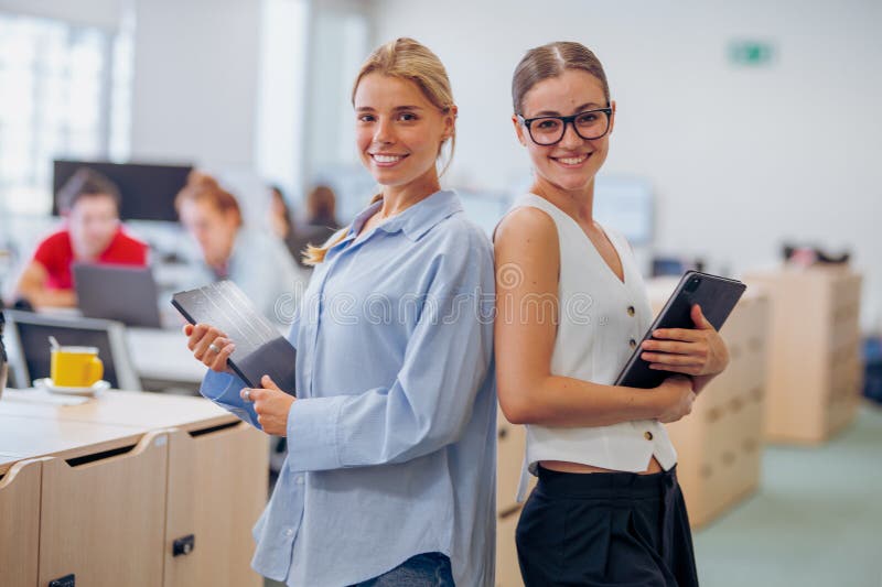 Two Smiling Businesswomen Collaborate in a Modern Office Setting ...