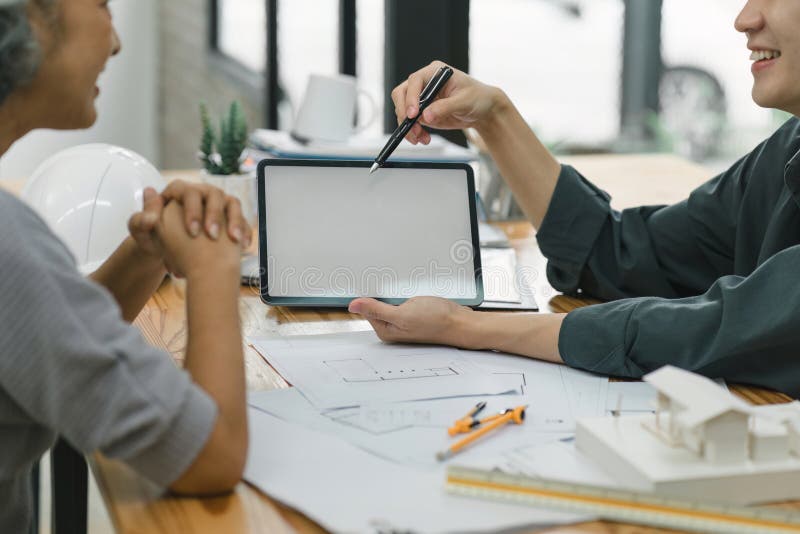 Two Professionals Engaged in a Detailed Discussion Over a Digital ...