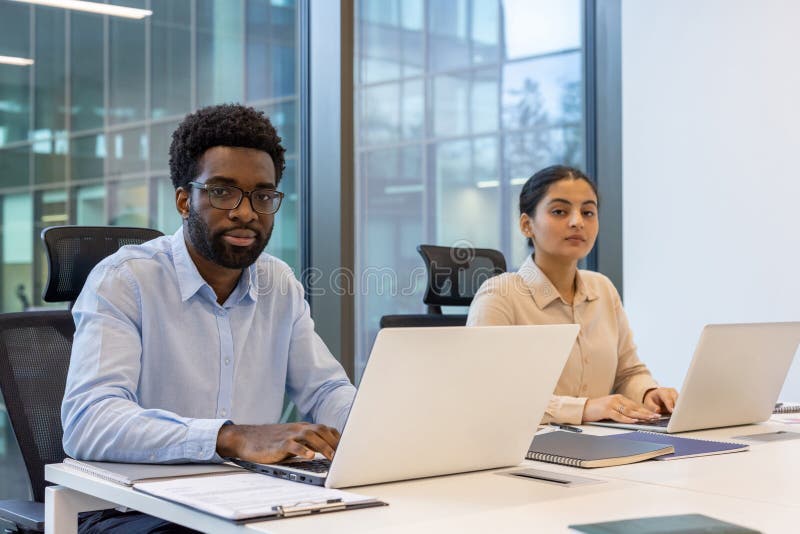 Professional Colleagues Working on Laptops in Modern Office Setting ...