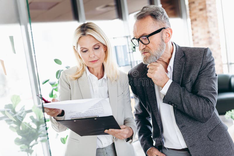 Professional Colleagues Analyzing Documents in a Modern Office ...