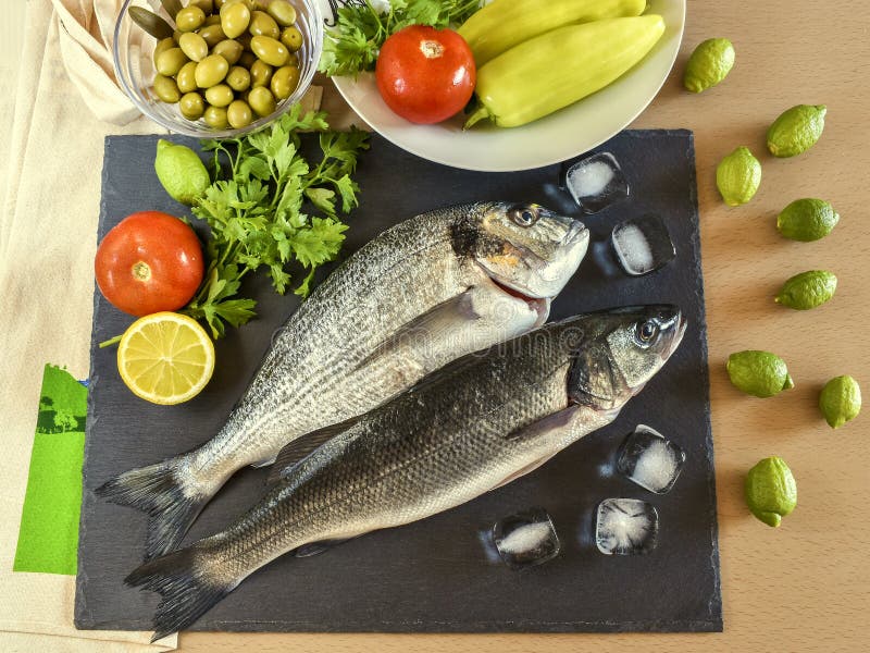 Two Ready To Cook Raw Fish with Vegetables on Stone Slate Board. Stock ...
